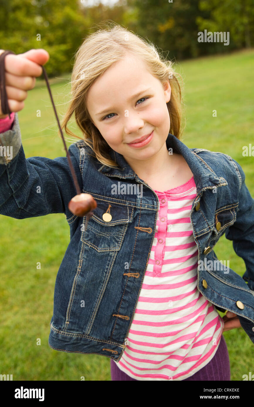 Girl playing with chestnut on string Stock Photo - Alamy