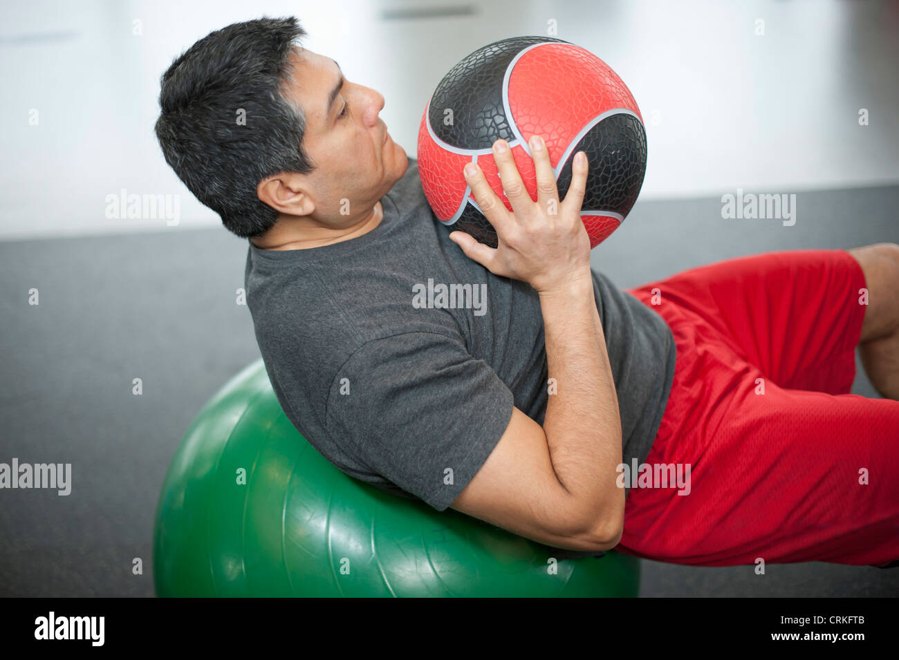 Man using exercise ball in gym Stock Photo - Alamy