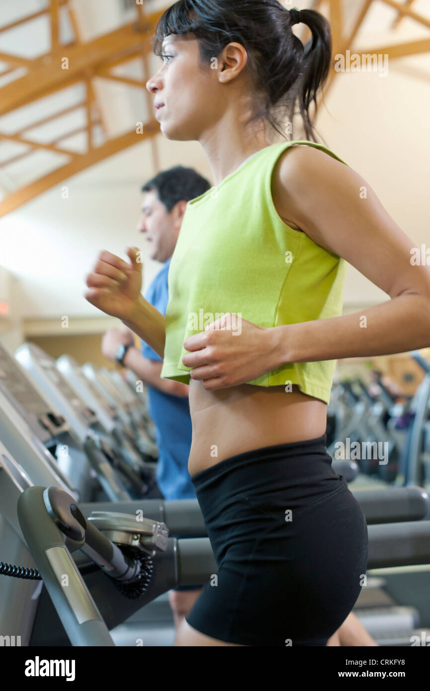 Woman using treadmill in gym Stock Photo - Alamy