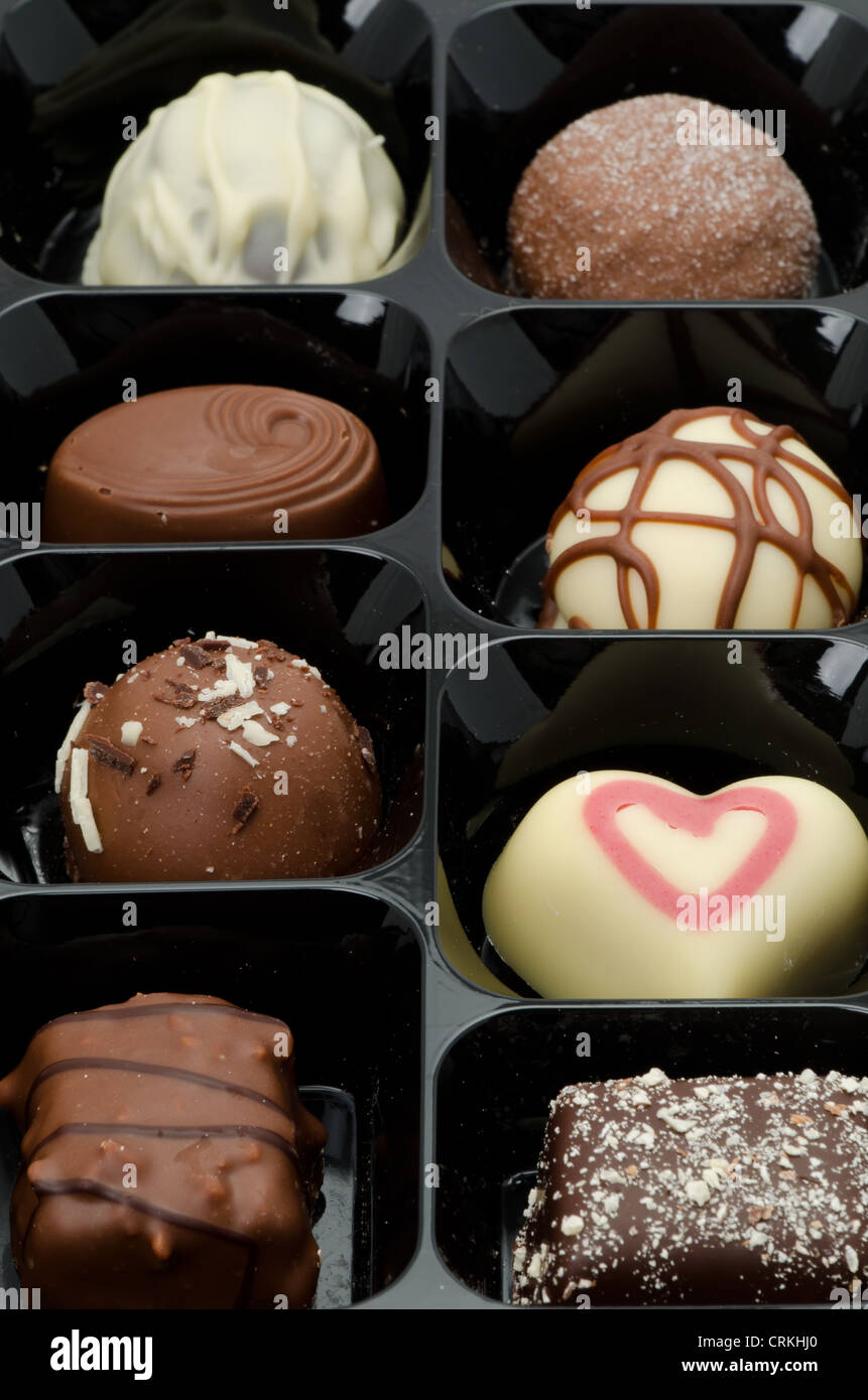 An opened box of Belgian chocolates - studio shot with a shallow depth ...