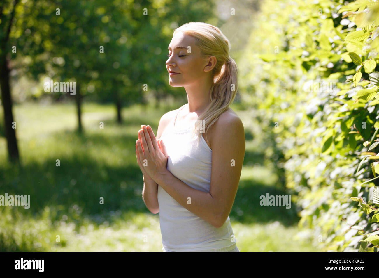 Woman alone standing prayer hands hi-res stock photography and images ...