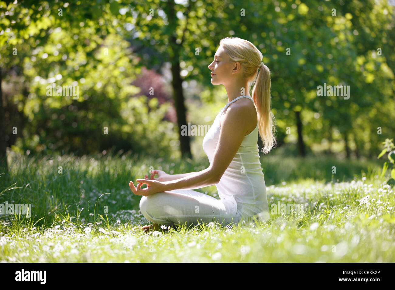 A young woman meditating outside Stock Photo - Alamy
