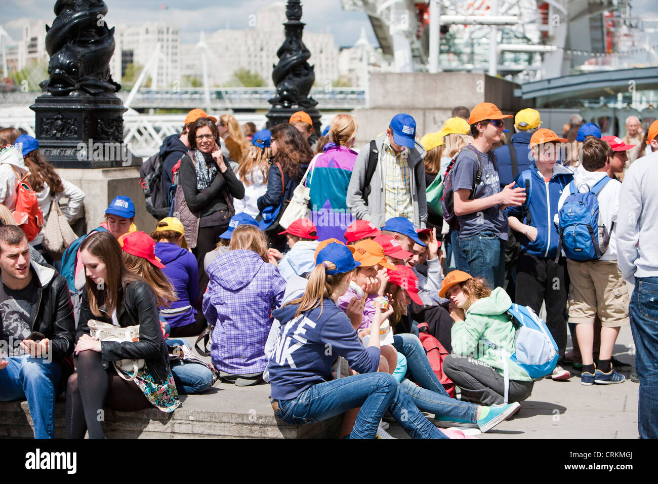 A group of young students all wearing baseball caps, beneath the London ...
