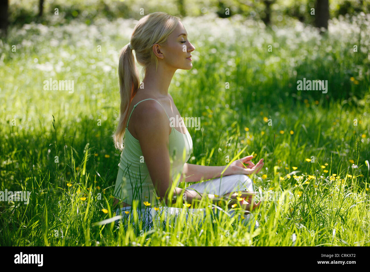 A young woman meditating outside Stock Photo - Alamy
