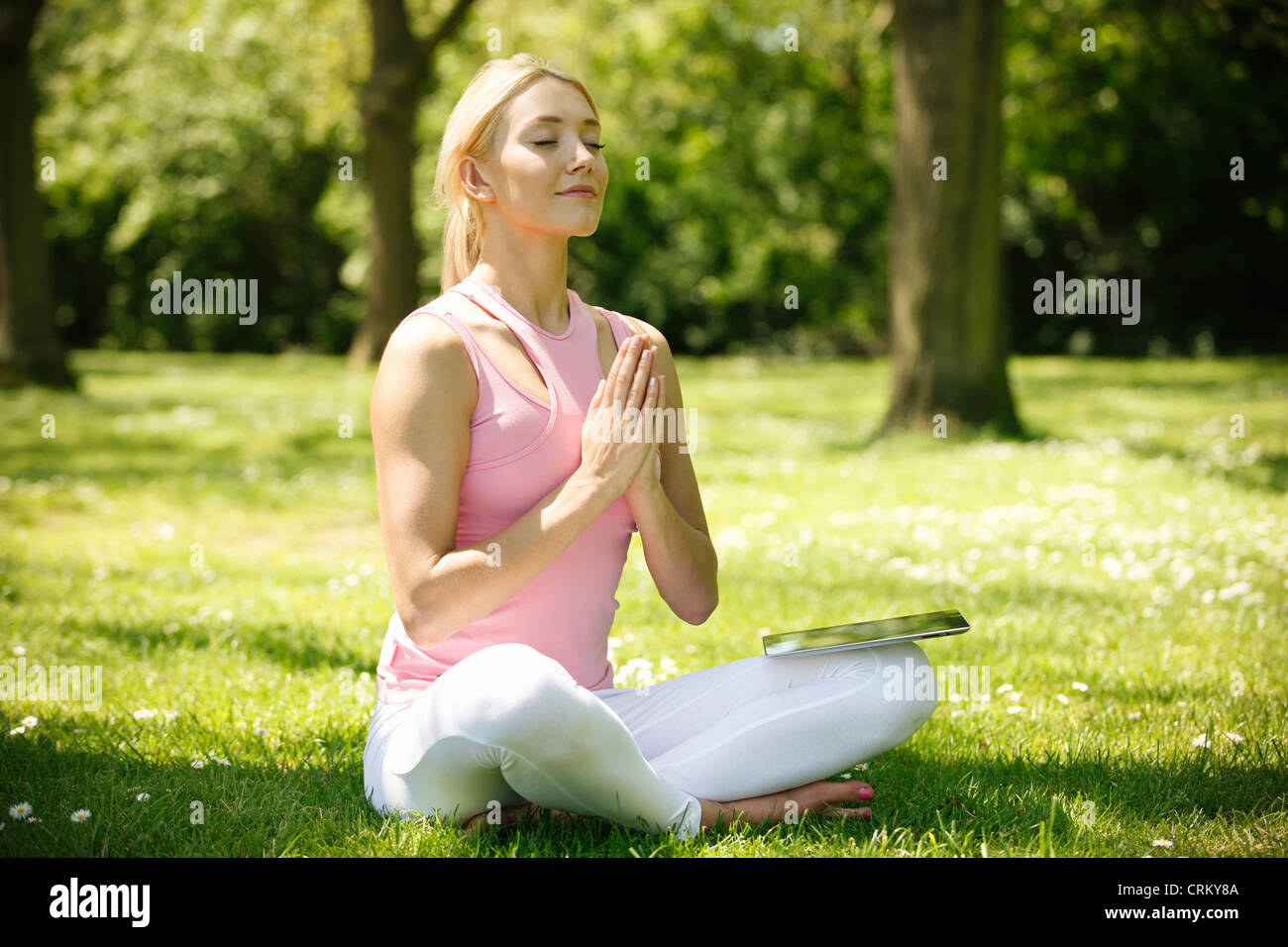 A young woman practicing yoga outside, hands in prayer position Stock ...