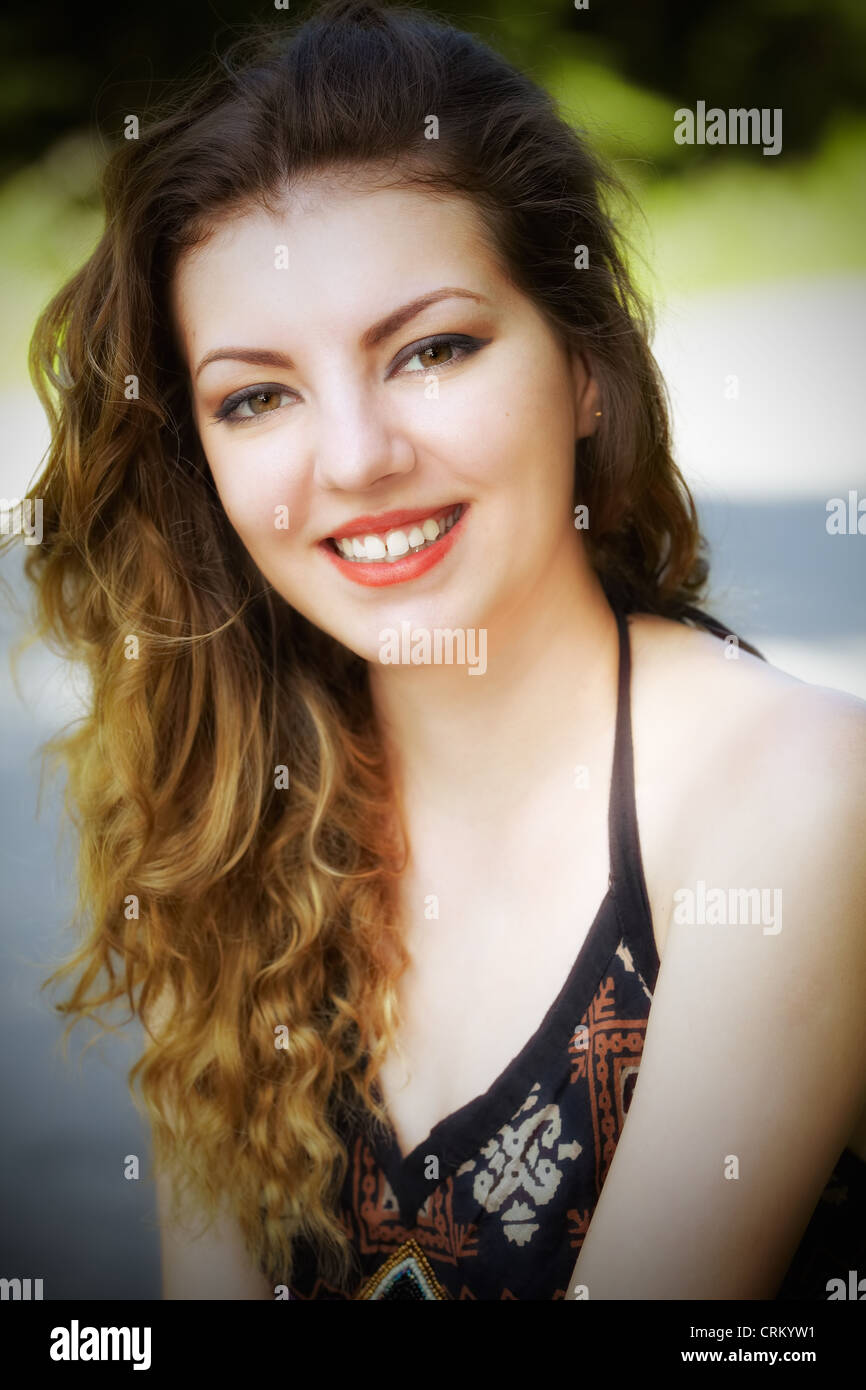 Portrait of a beautiful 20 year old woman enjoying a summer day outdoor ...