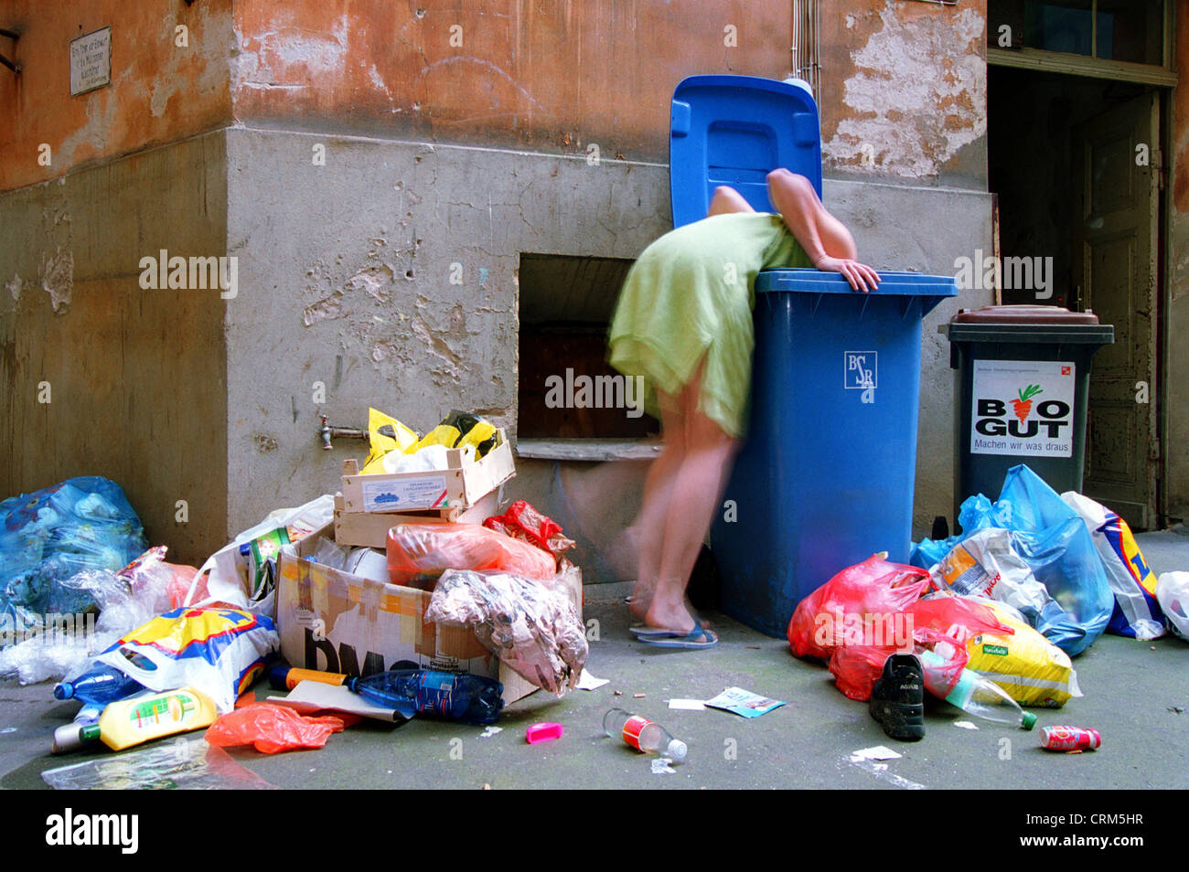 Woman hangs looking over the edge of a garbage can Stock Photo - Alamy