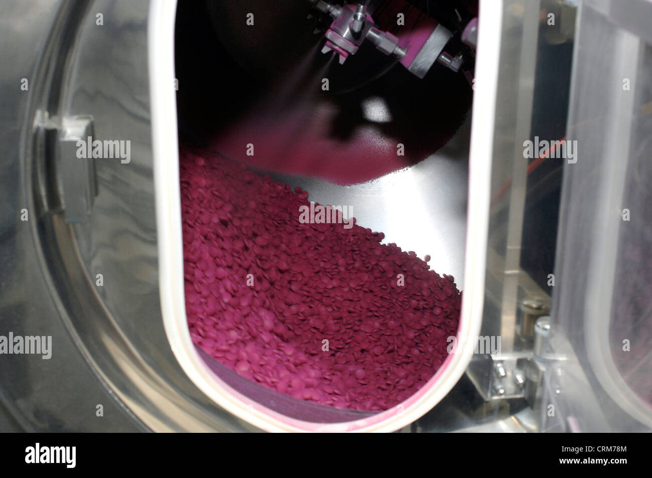 Close up of drugs in a vat room being coated with sugar and colouring ...