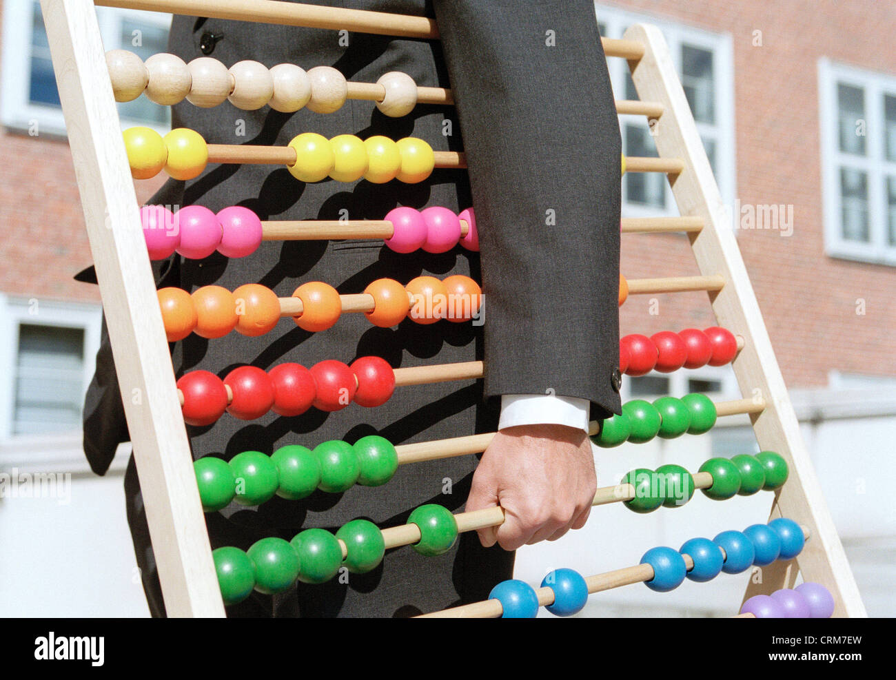 Man in a suit carries an abacus under his arm Stock Photo - Alamy
