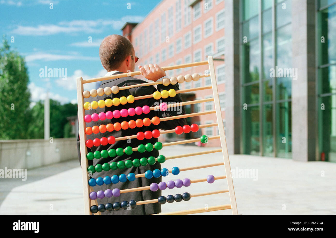 Man in a suit carries abacus in front of a office building Stock Photo ...