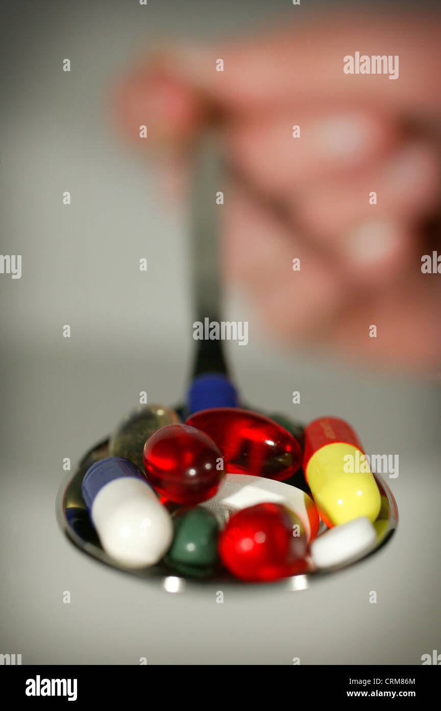 A spoonful of coloured pills and capsules Stock Photo - Alamy