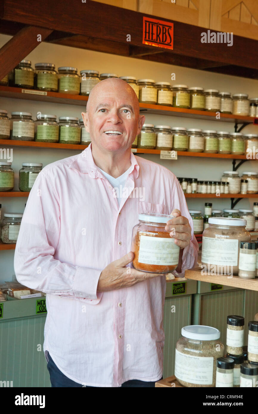 Portrait of a senior man standing with spice jar in store Stock Photo ...