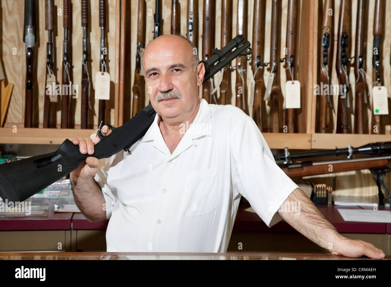 Portrait of a mature man with rifle on shoulder in gun store Stock ...