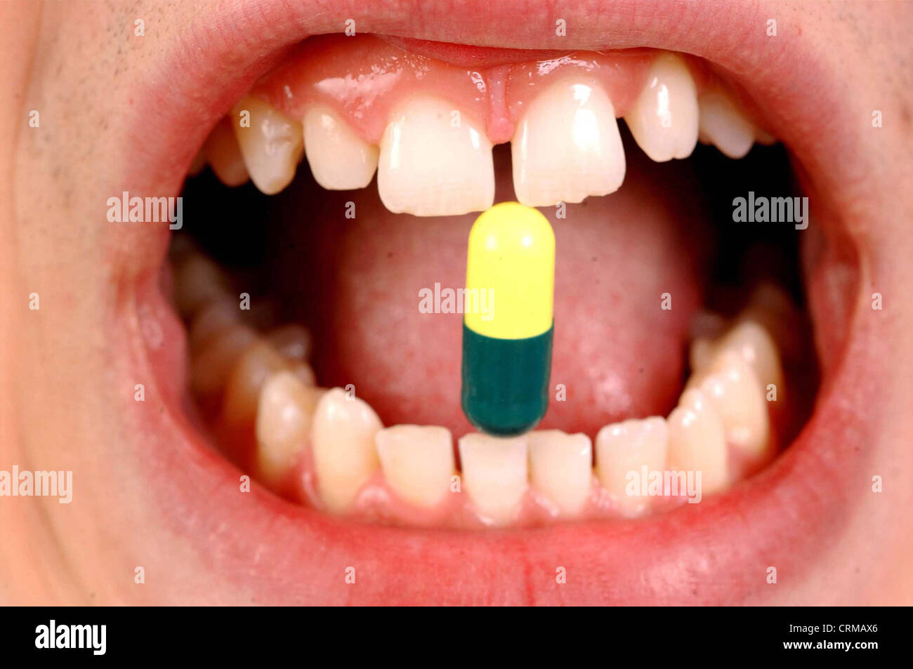 Man with a capsule in his mouth Stock Photo - Alamy