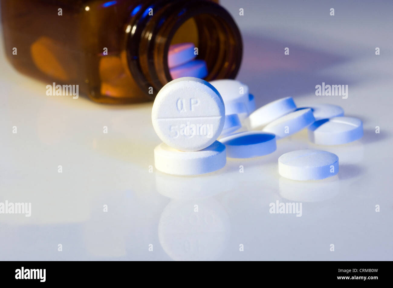 White tablets spill from a medicine bottle Stock Photo - Alamy
