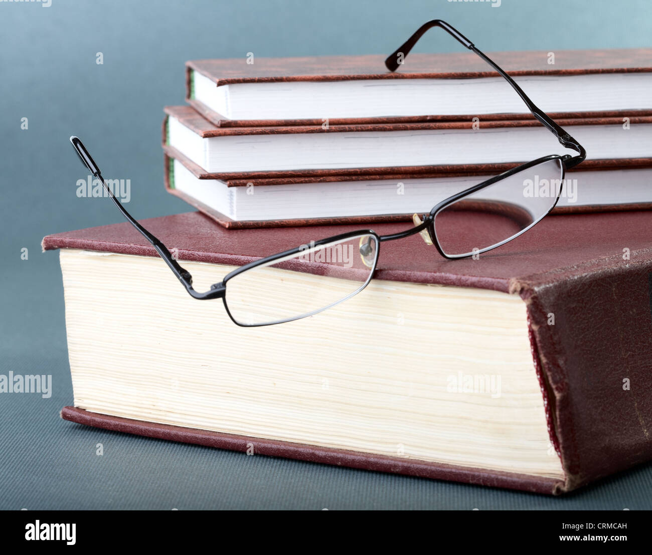 Pile of books and glasses on old thick volume Stock Photo - Alamy