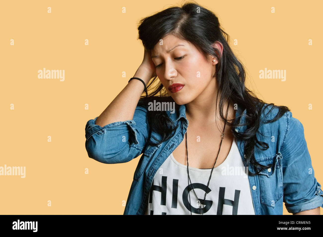Young woman with hands in hair over colored background Stock Photo - Alamy