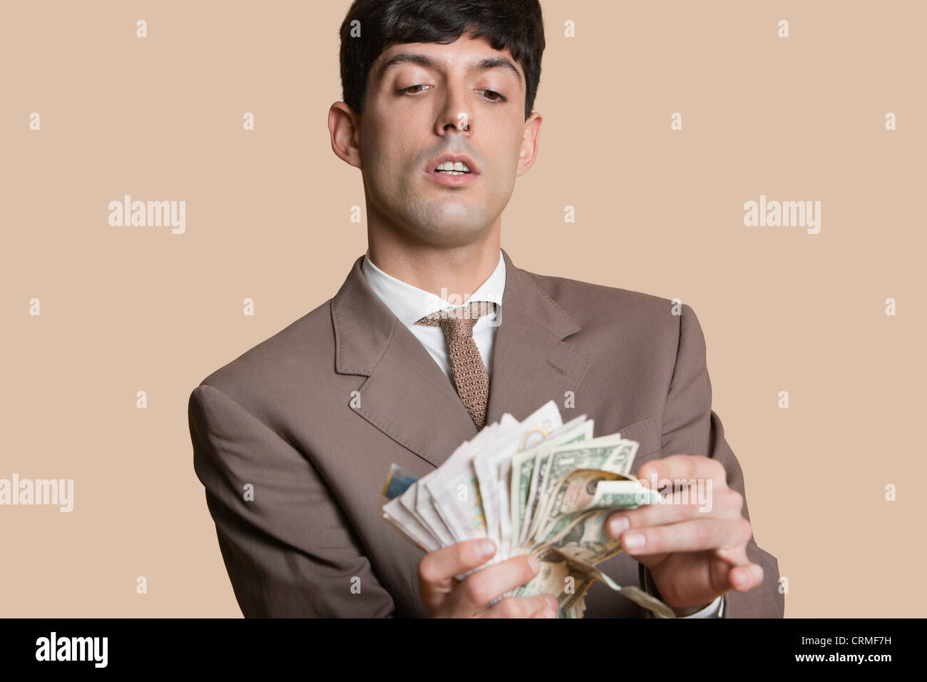 Young businessman counting money over colored background Stock Photo ...