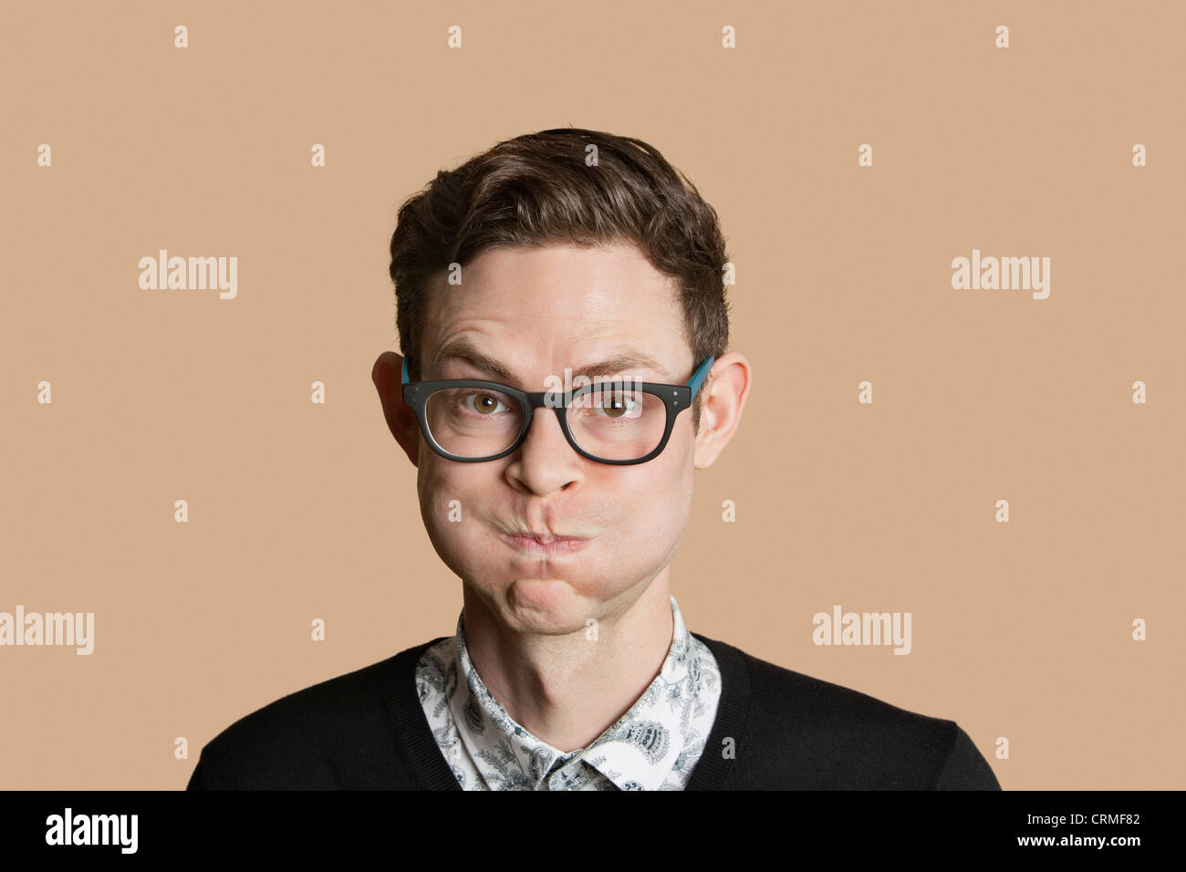 Portrait of mid adult man puffing cheeks over colored background Stock ...