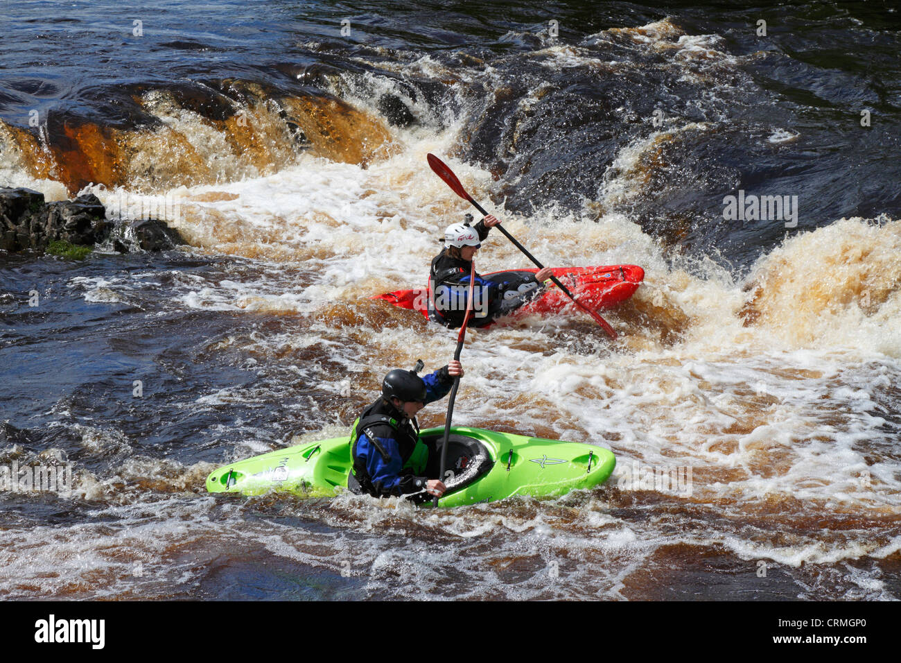 Two people whitewater kayaking on the River Tees at Low Force waterfall ...