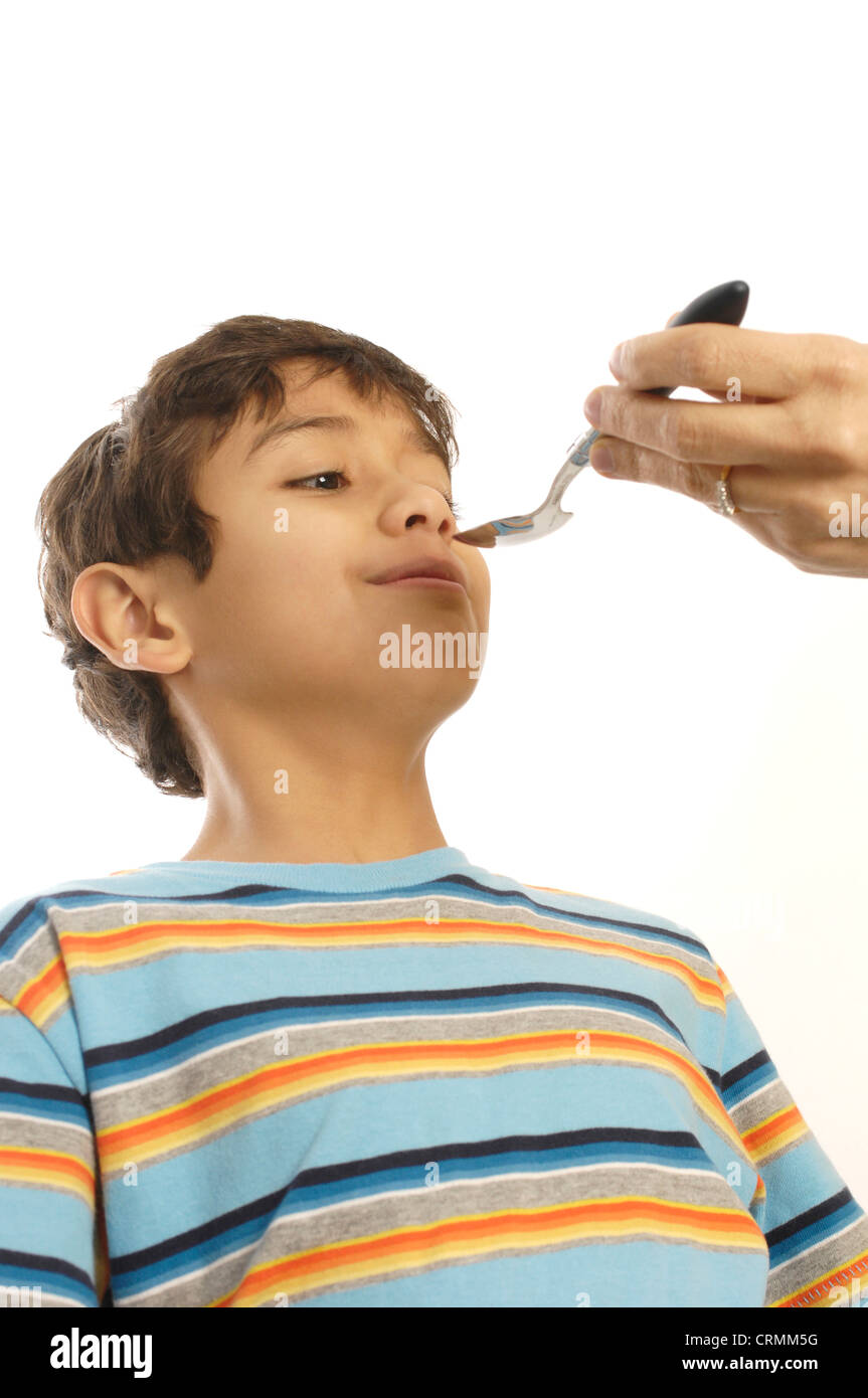 A young boy refusing to take cough syrup from his mother Stock Photo ...