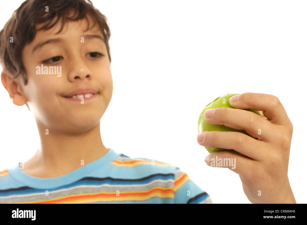 A young boy holding up an apple and looking at it Stock Photo - Alamy