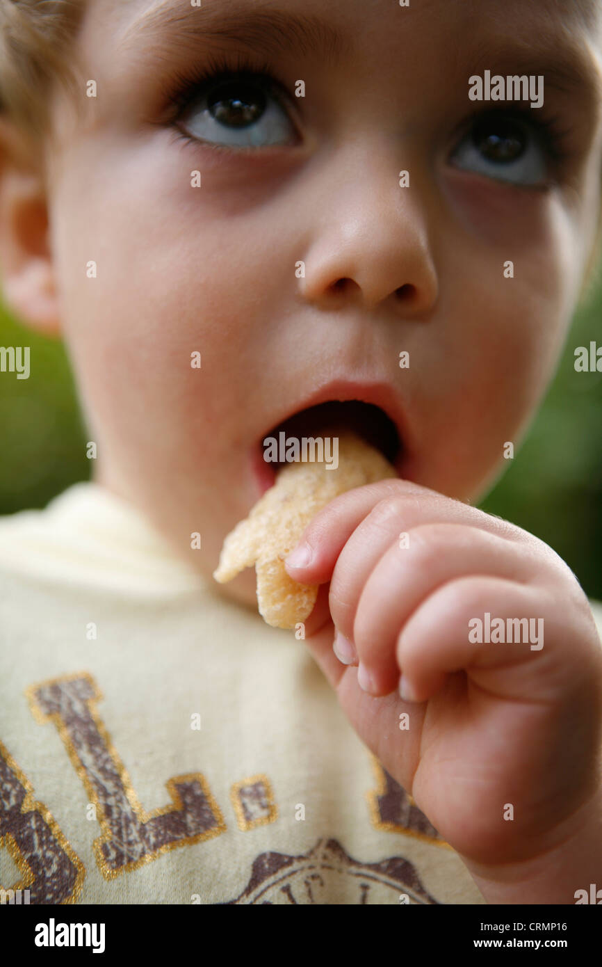 A baby nibbles on an unhealthy potato crisp Stock Photo - Alamy