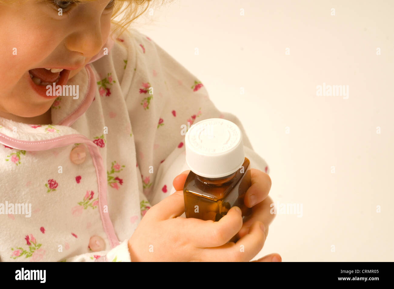 A young infant trying to open a medication bottle Stock Photo - Alamy