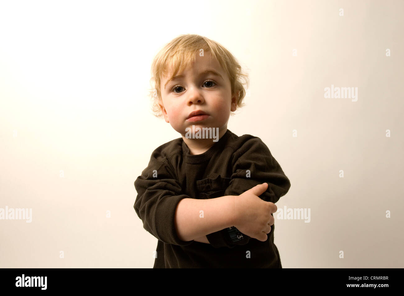 A young boy standing with his arms crossed Stock Photo - Alamy