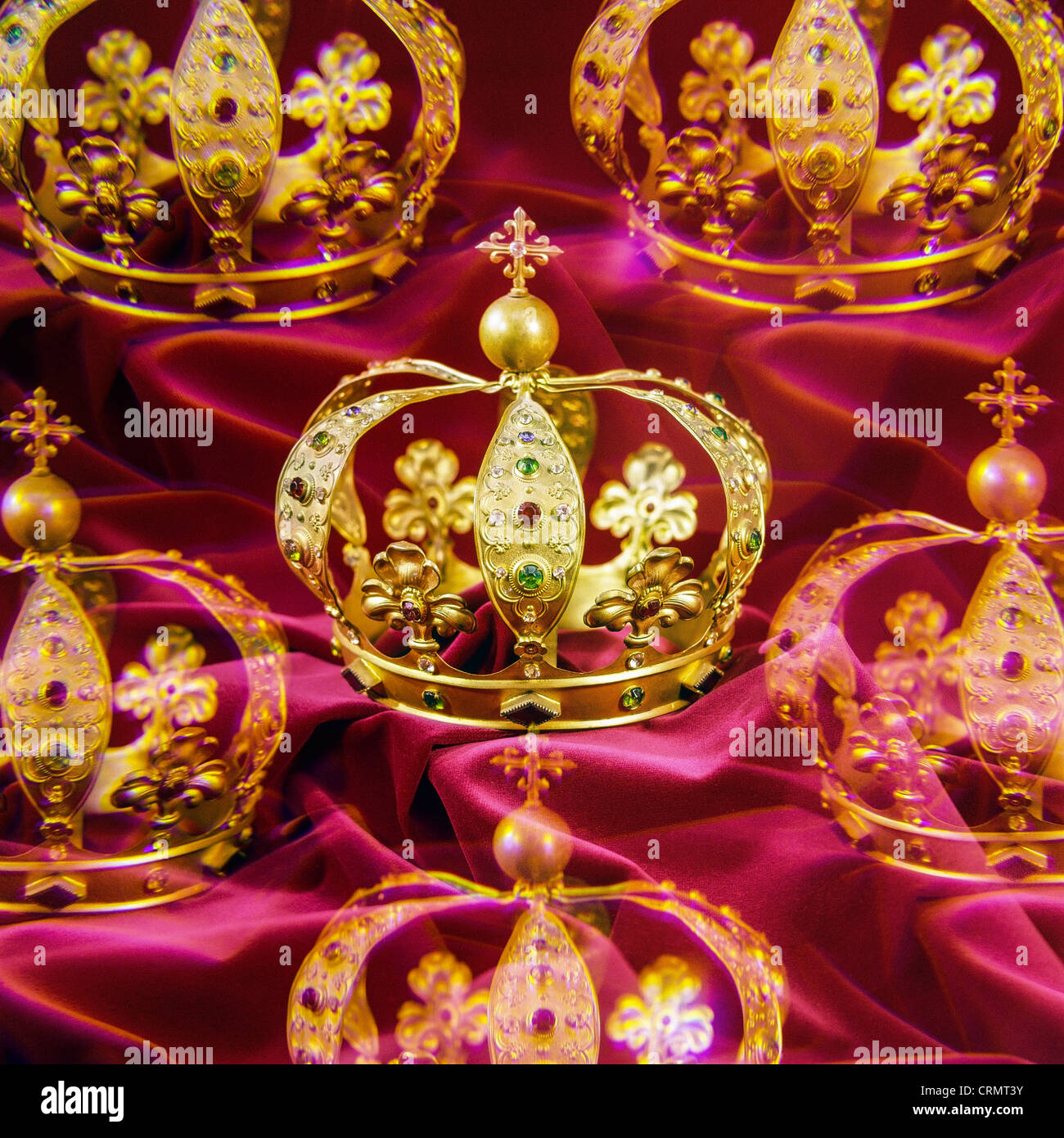 Multiple golden crown on garnet velvet Stock Photo - Alamy
