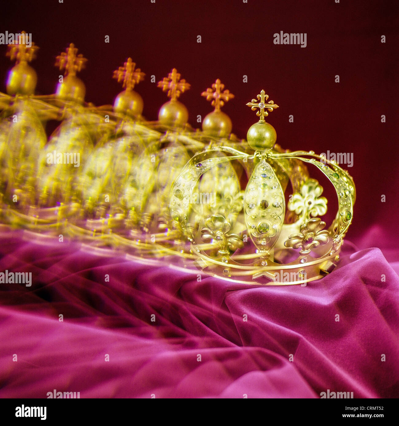 Multiple golden crown on garnet velvet Stock Photo - Alamy