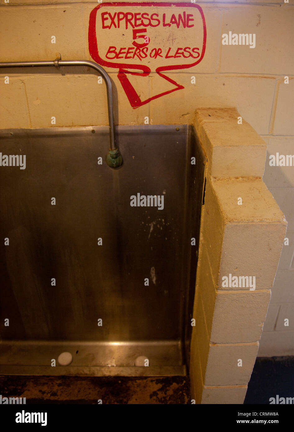 Toilet humour 'Express Lane 5 Beers or Less' sign painted above urinal ...