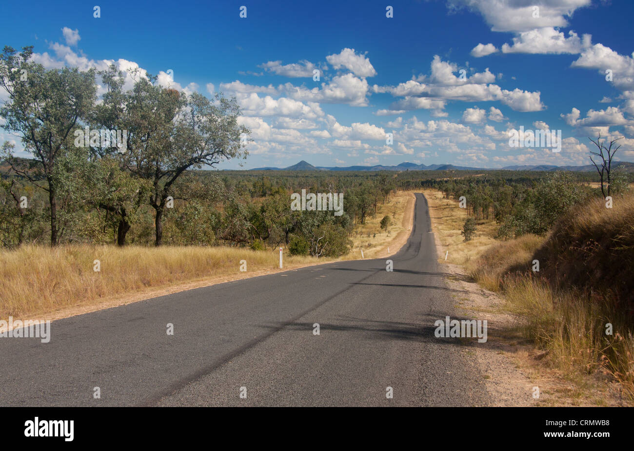 Outback / bush country road near Clermont down hill with flat landscape ...