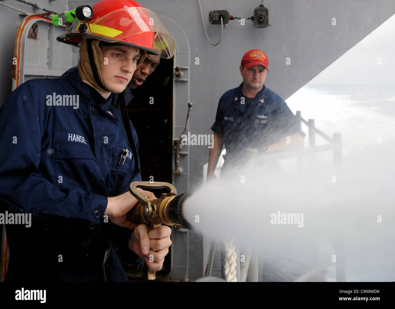 Electrician's Mate 3rd Class Nicholas Hansen practices with a fire hose ...