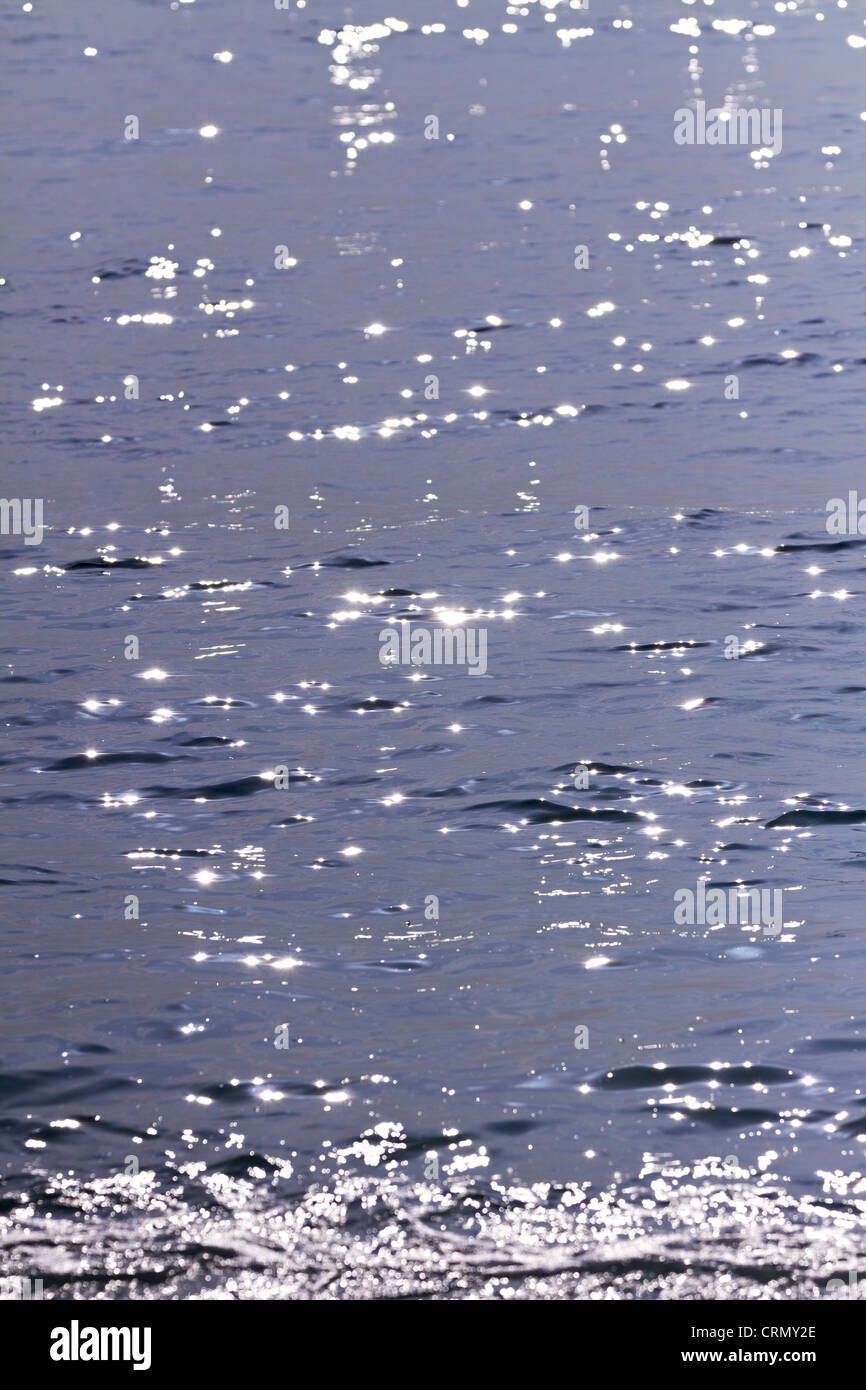 Ocean water ripples surface in back lighting as background Stock Photo ...