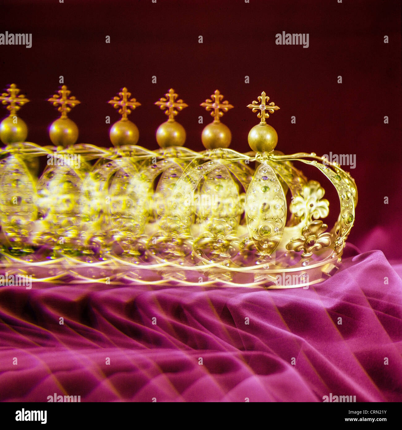 Multiple golden crown on garnet velvet Stock Photo - Alamy