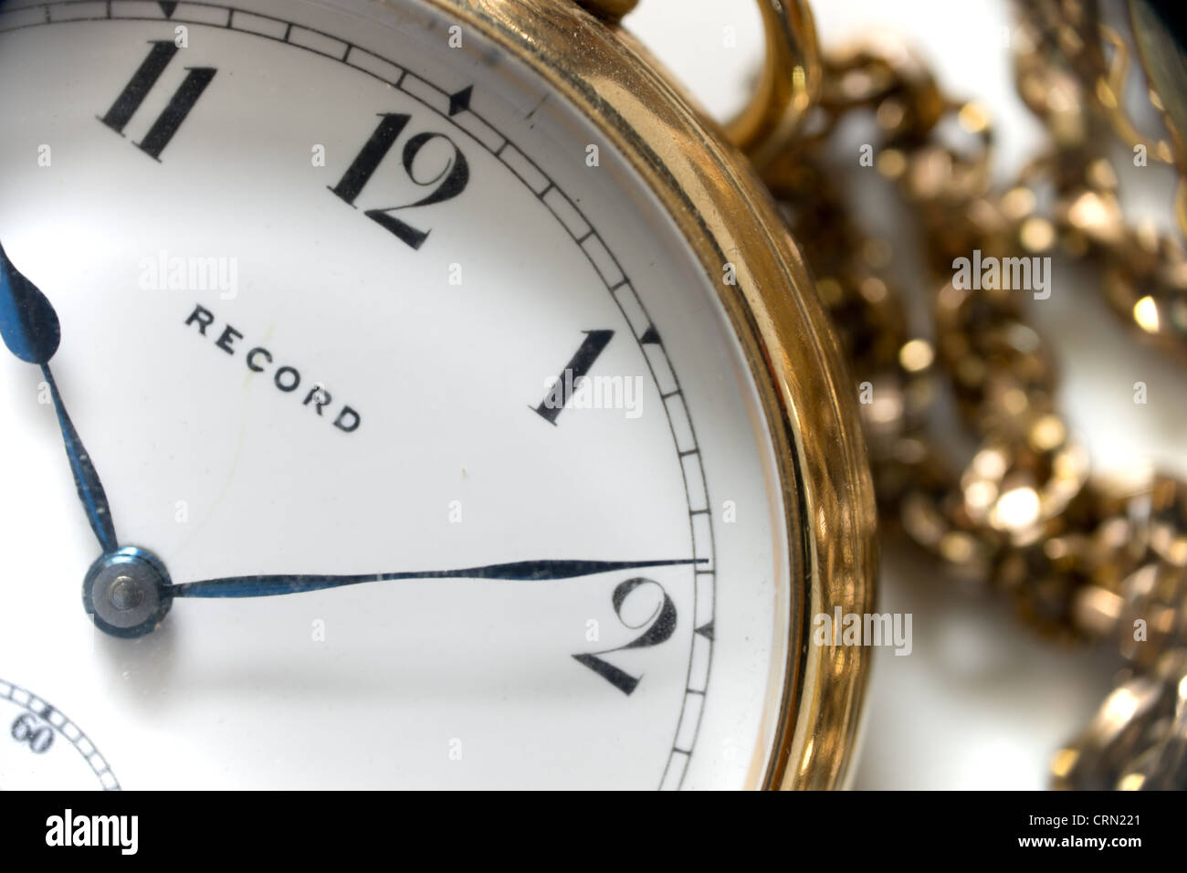 A gold pocket watch by Record with Arabic numerals and intricate gold ...