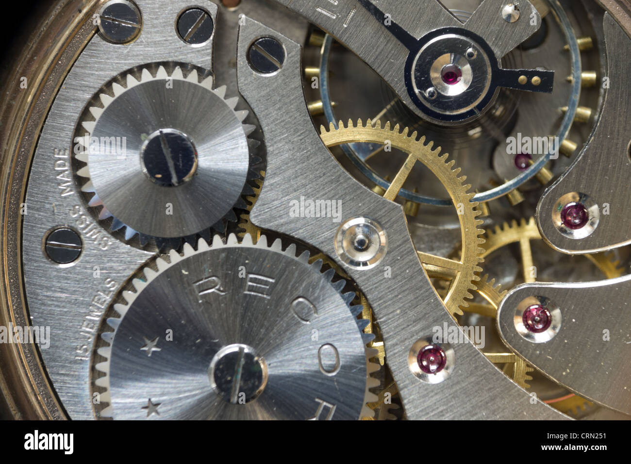 A gold pocket watch with back opened to show interior workings ...