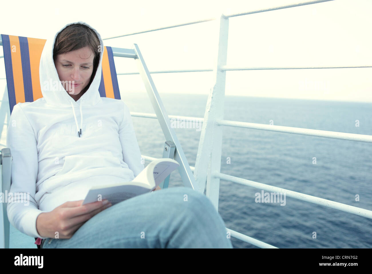 Portrait of a young woman reading a book on a liner in the middle of a ...