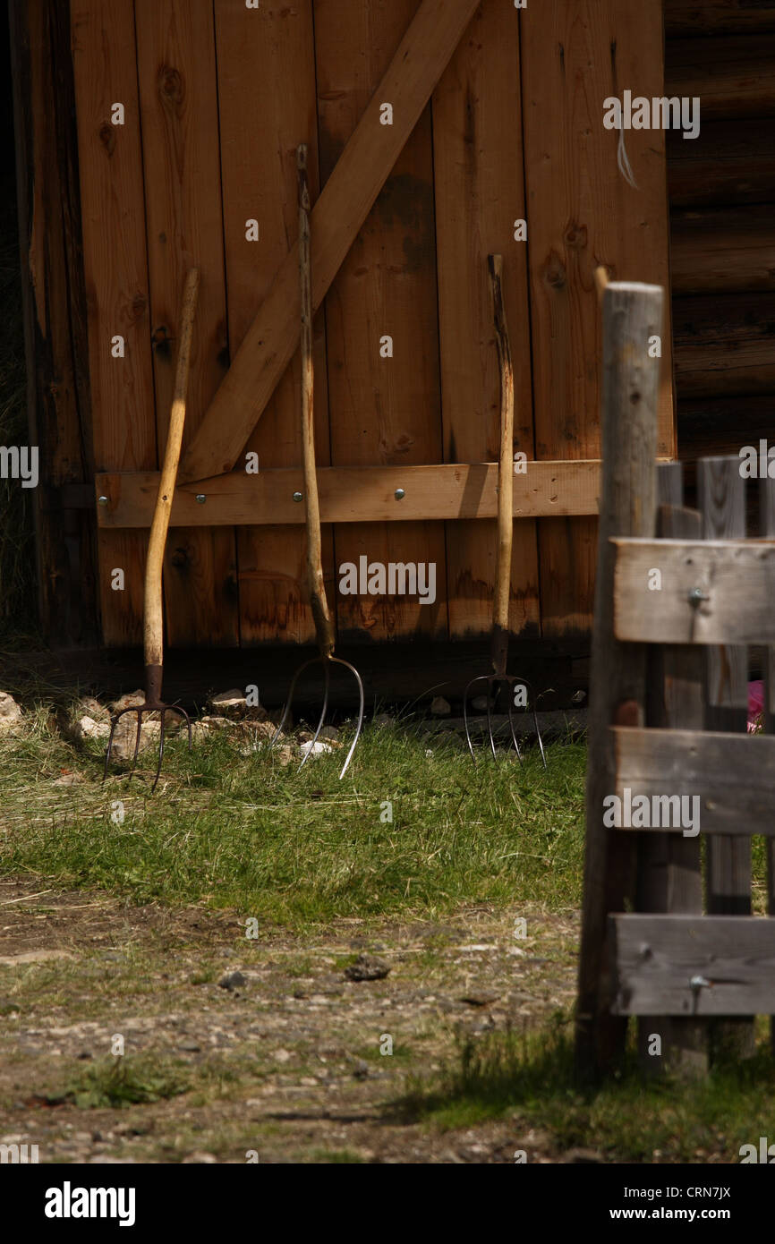 Farming tools by a barn in warm evening sun Stock Photo - Alamy