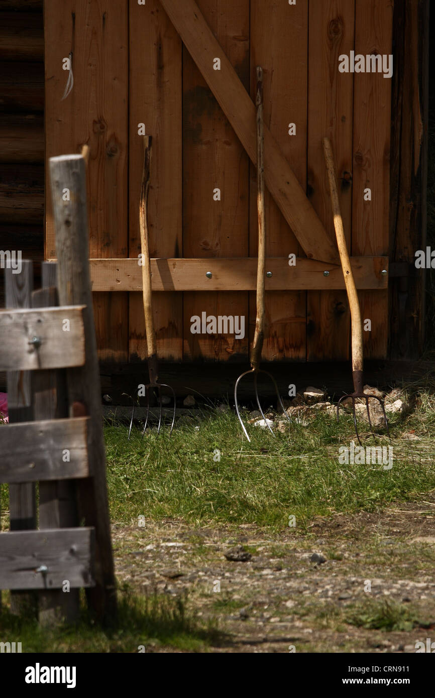 Farming tools by a barn in warm evening sun Stock Photo - Alamy