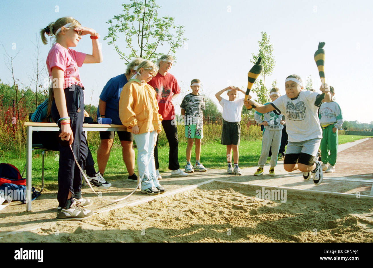 Children during school sports - long jump Stock Photo - Alamy