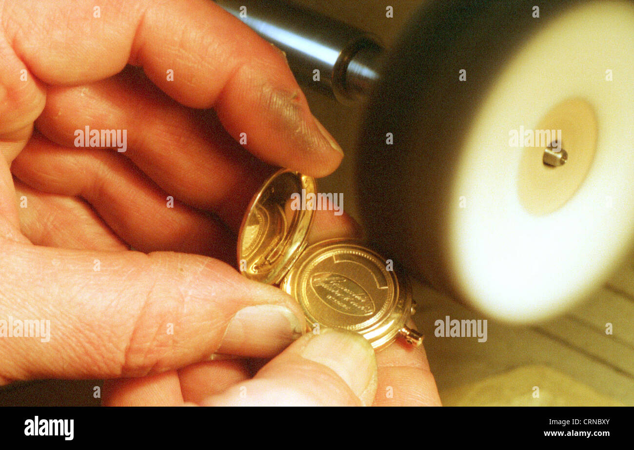 Polishing an old pop-up lid-clock, Berlin Stock Photo - Alamy