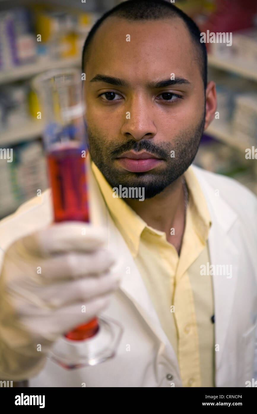 Pharmacist checks quantity red solution in hi-res stock photography and ...