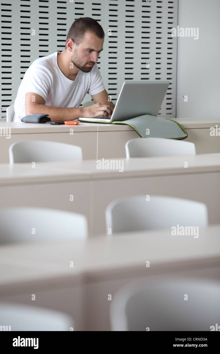 Young male college student working on his laptop computer Stock Photo ...