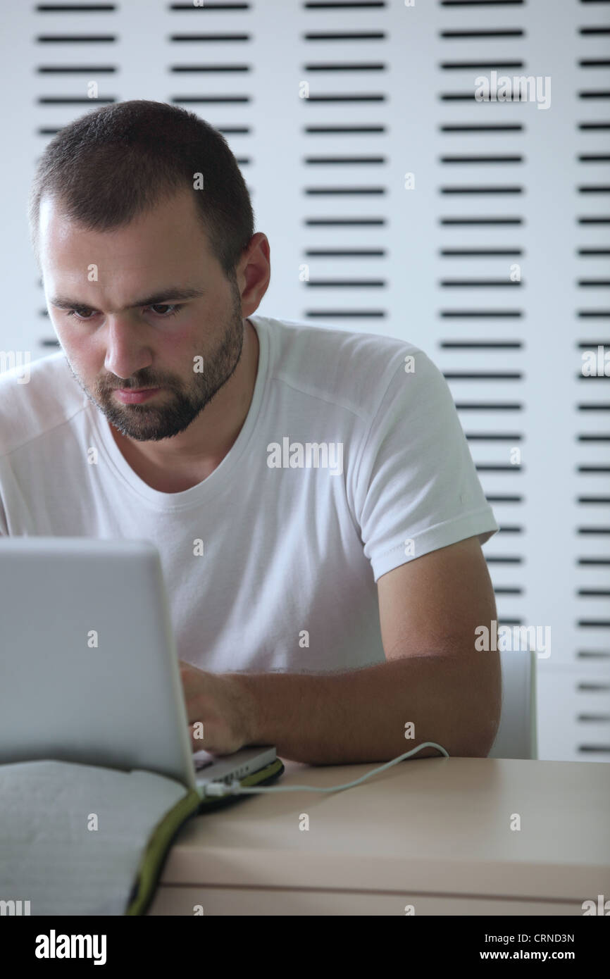 Young male college student working on his laptop computer Stock Photo ...
