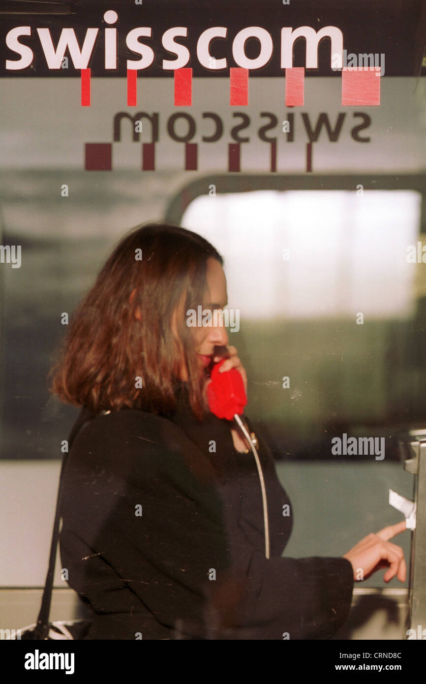 A woman is standing in a phone booth of the Swiss telecommunications ...