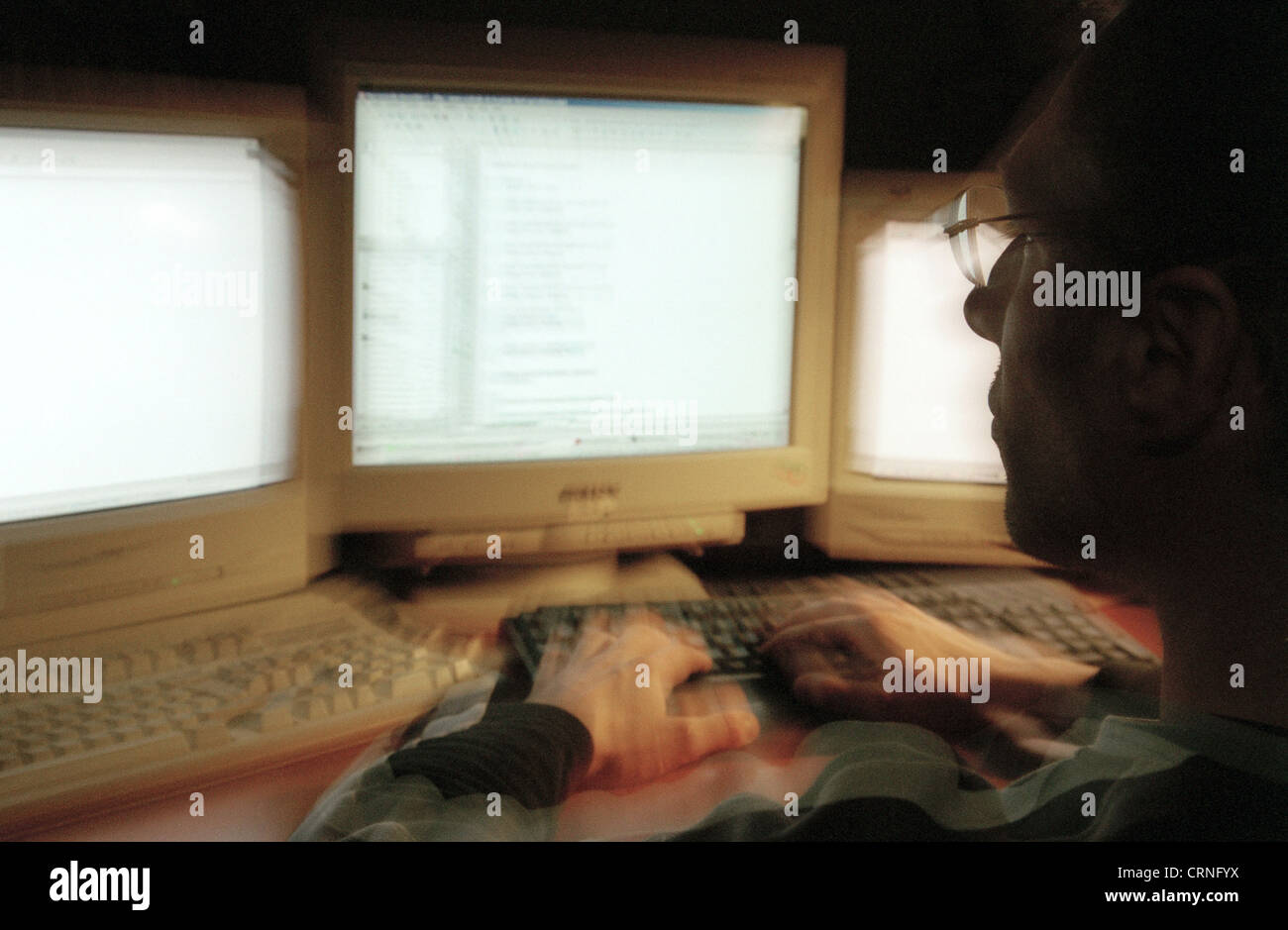 A young man sitting in front of computer monitors Stock Photo - Alamy