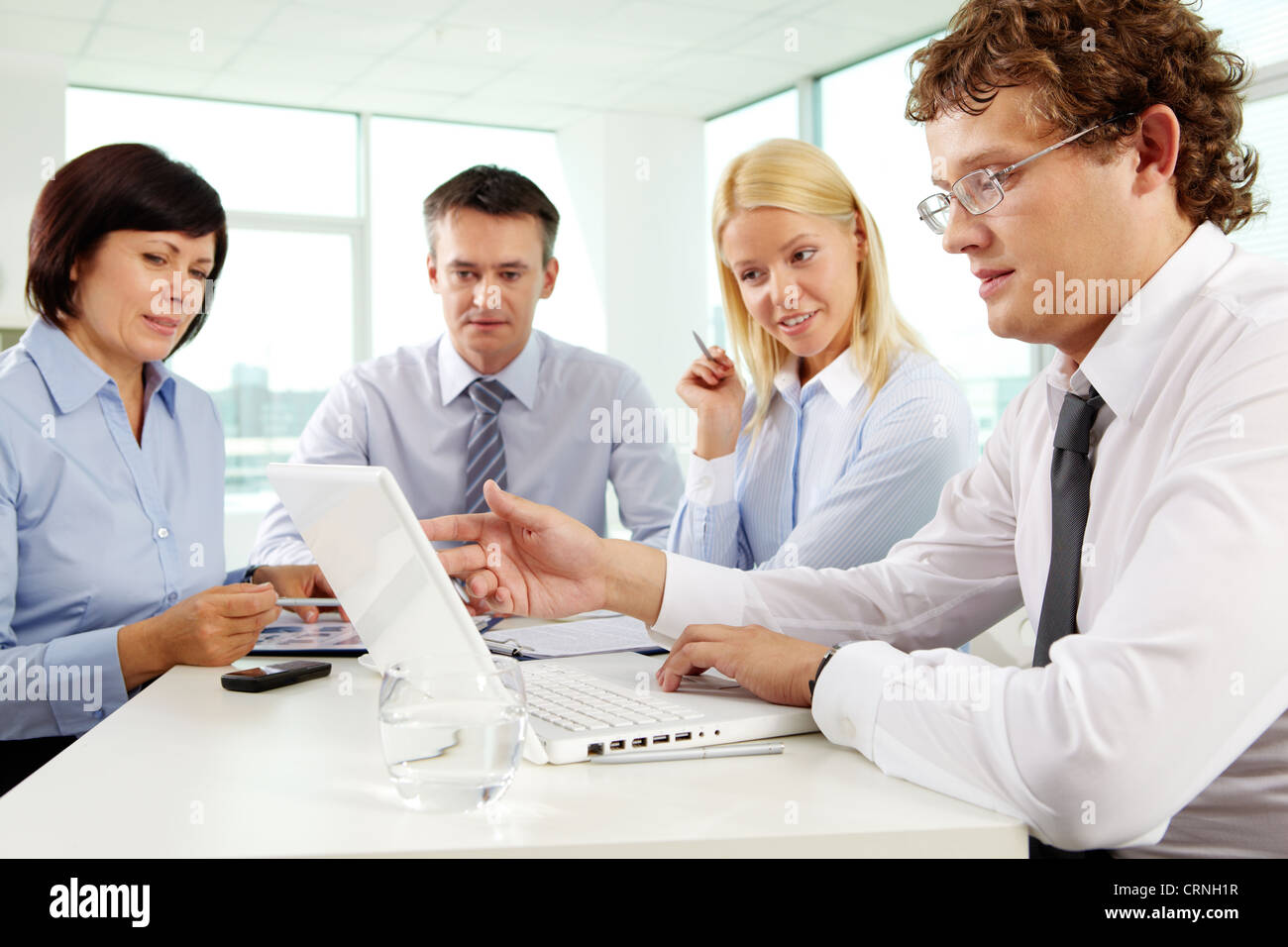 Business people looking at the screen of the laptop working at the ...