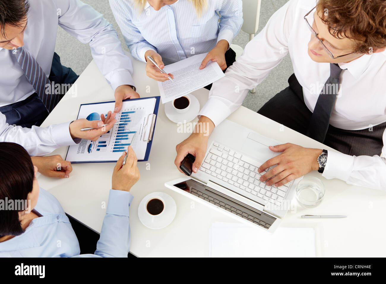 Business leader taking a close look at the charts and graphs at the ...